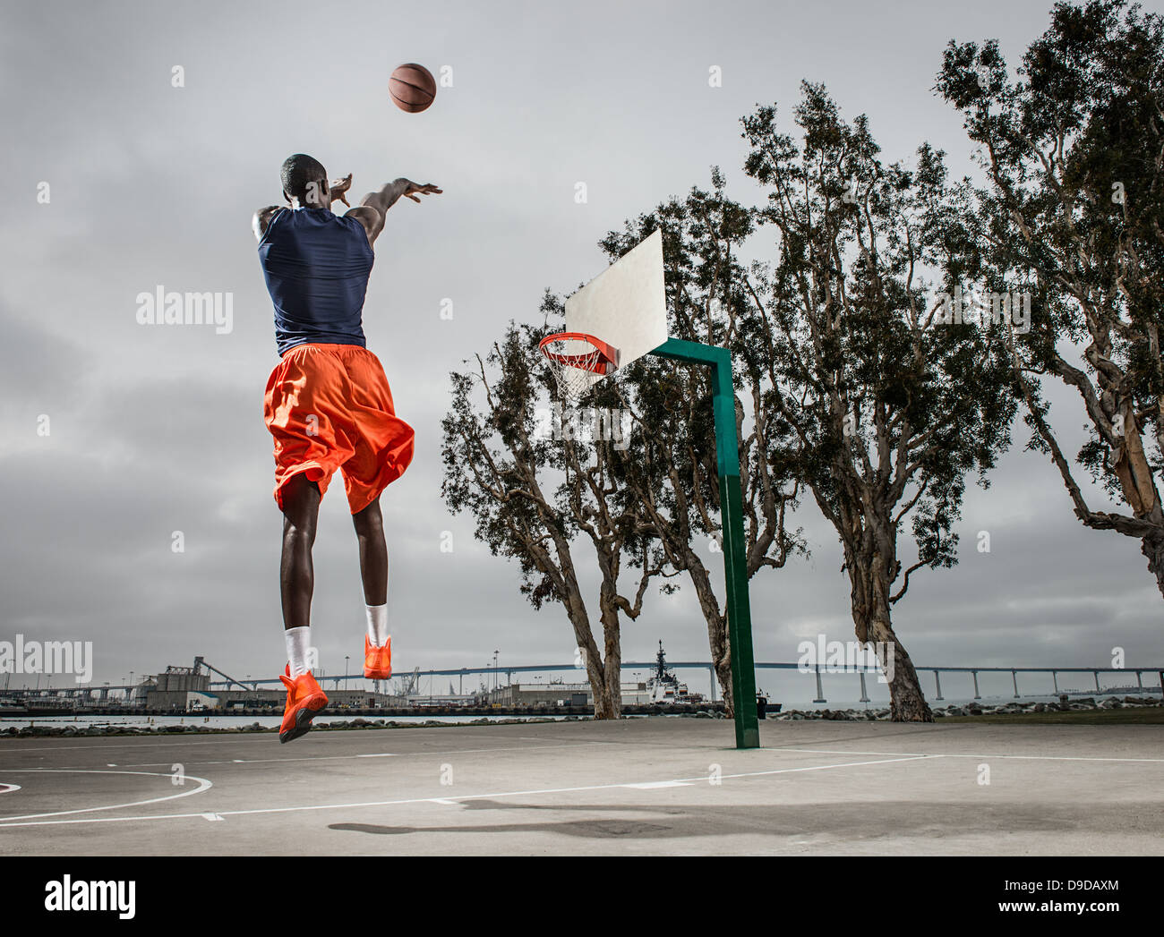Young basketball player jumping to score Stock Photo - Alamy