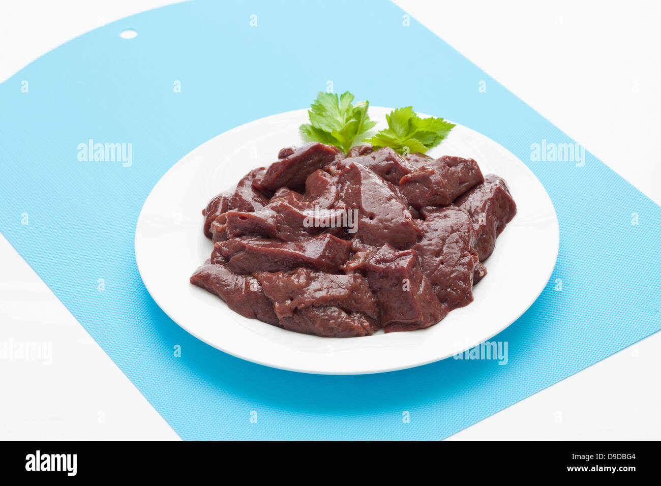 Calf liver pieces in plate on blue chopping board Stock Photo - Alamy