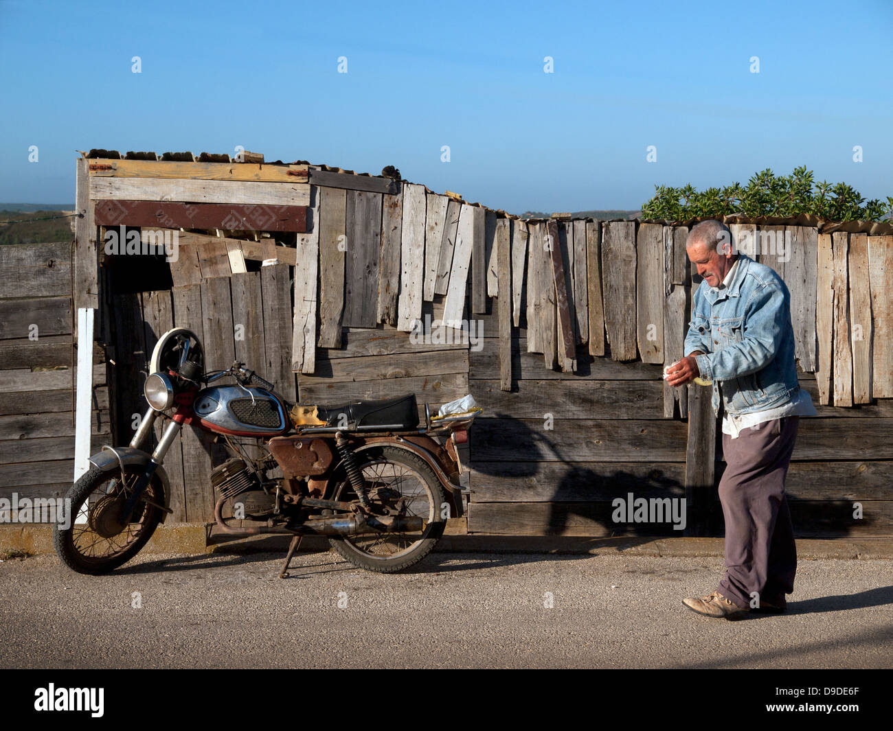 A man and his old motorbike outside a wooden shack in Portugal Stock ...