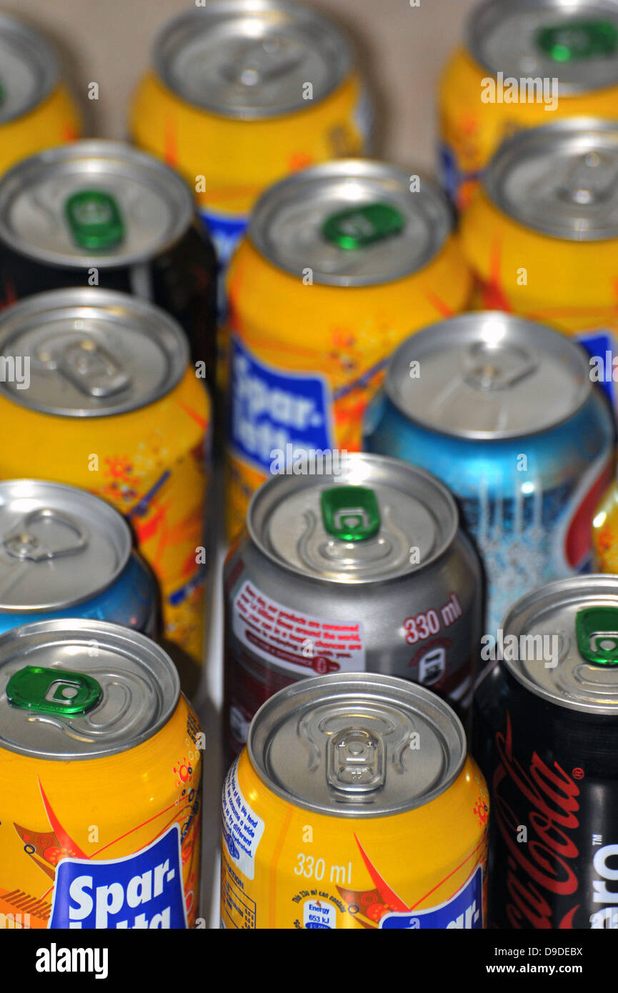 The tops of a variety of cans of fizzy pop photographed against a white ...