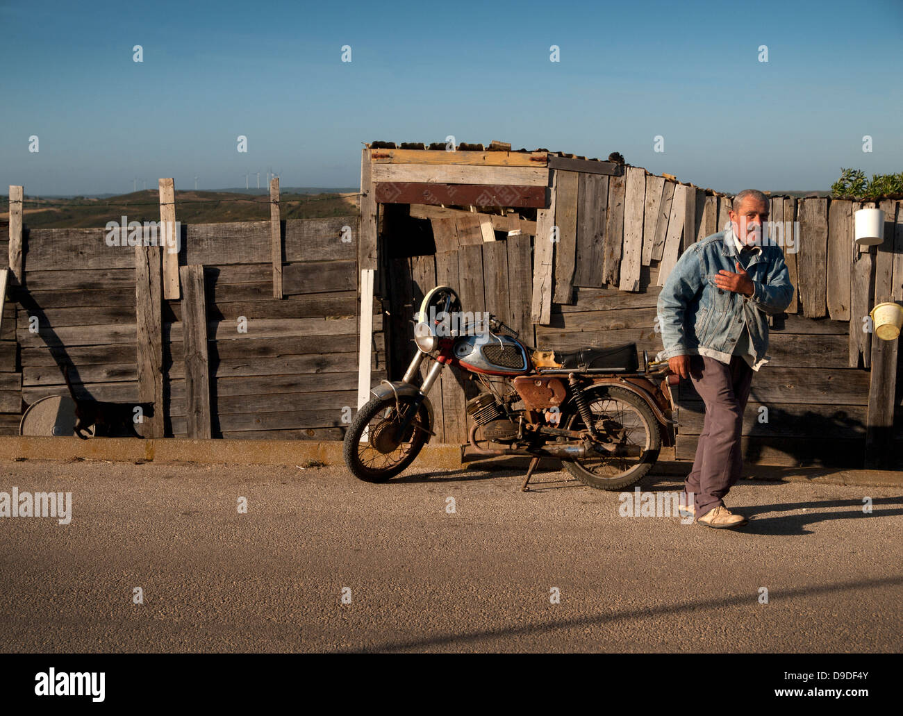 A man and his old motorbike outside a wooden shack in Portugal Stock ...