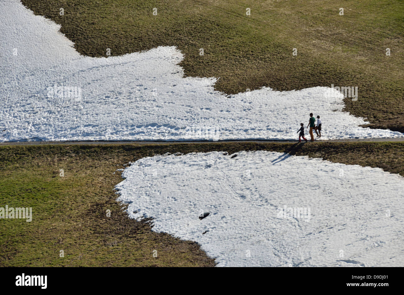 A family passing snow patches on a Swiss hillside Stock Photo - Alamy