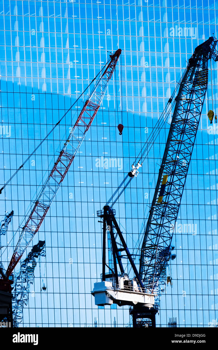 Construction cranes in front of office building Stock Photo - Alamy