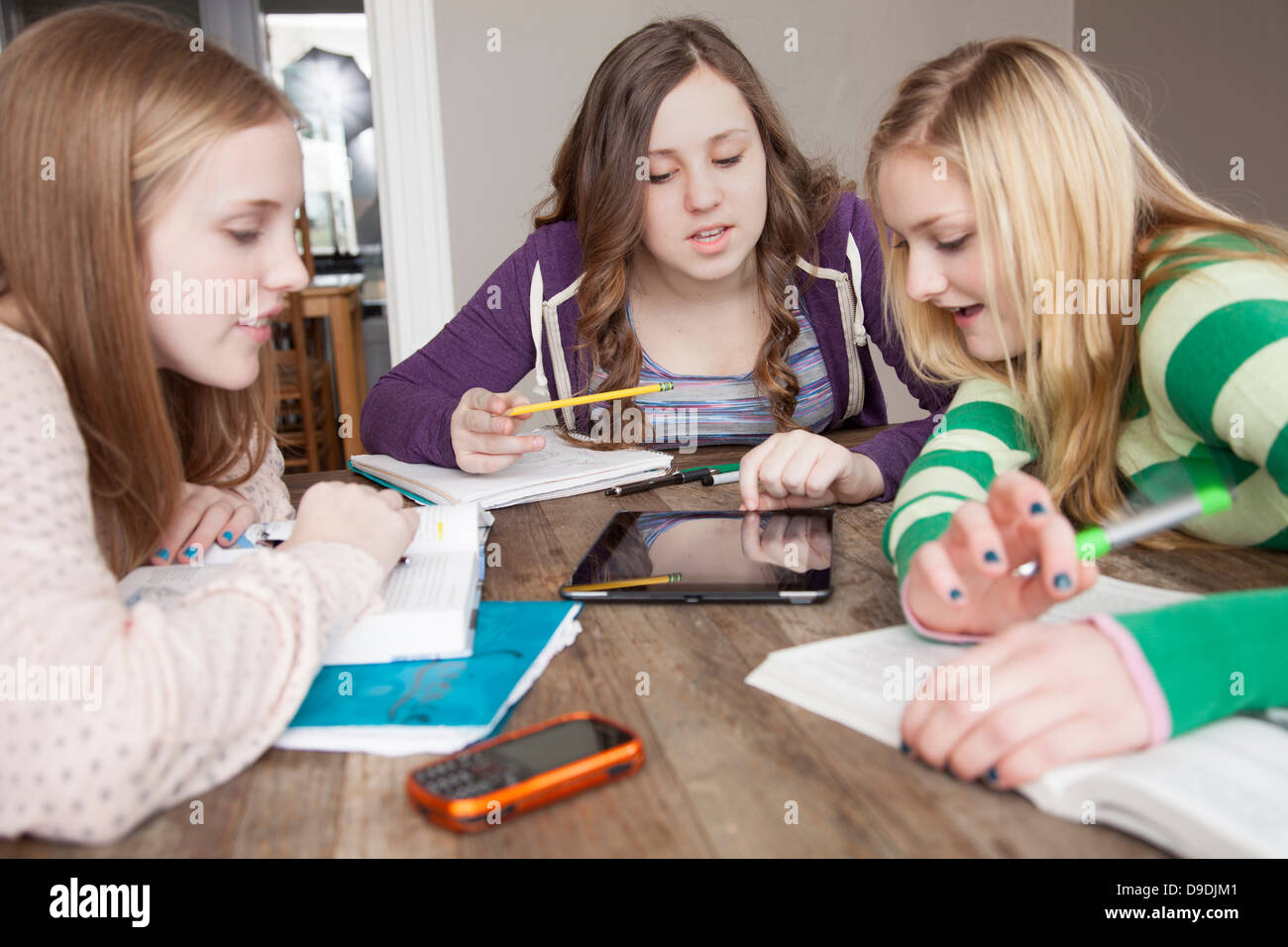 Girls sitting at table studying Stock Photo - Alamy