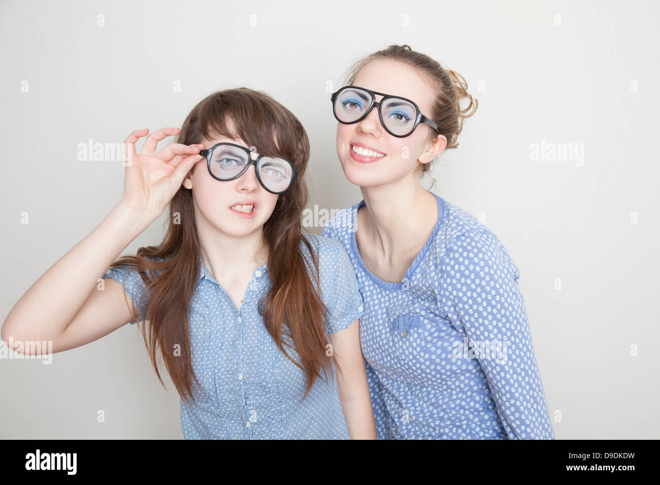 Two girls wearing fake glasses Stock Photo - Alamy