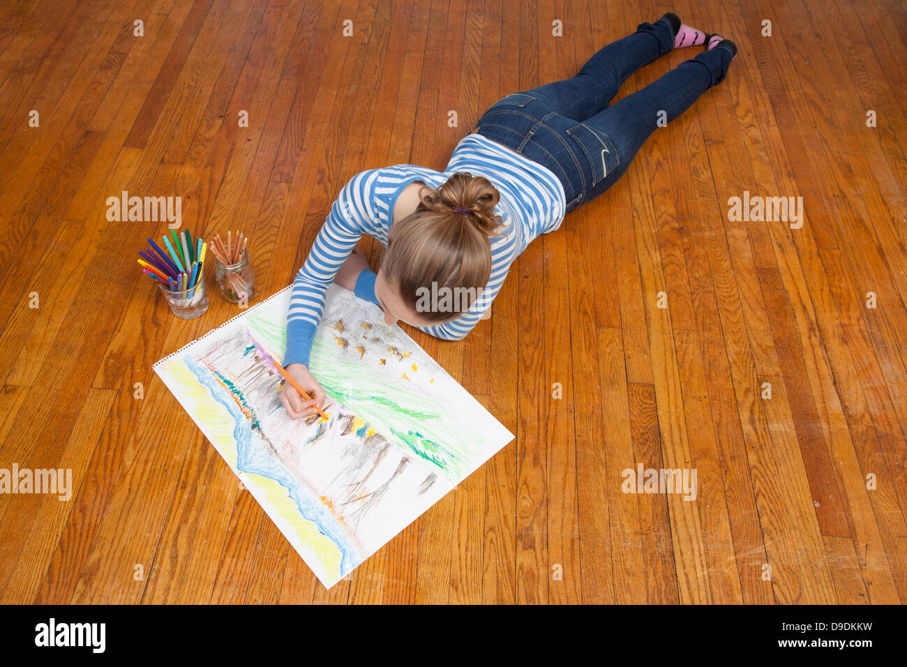 Girl lying on floor drawing picture Stock Photo - Alamy