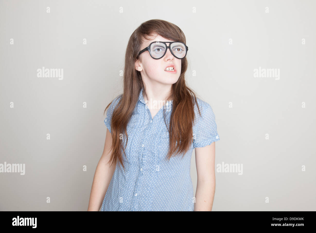 Girl wearing fake glasses grimacing Stock Photo - Alamy
