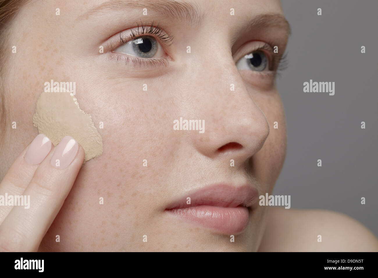 Close up of part of young woman's face, applying concealer Stock Photo ...