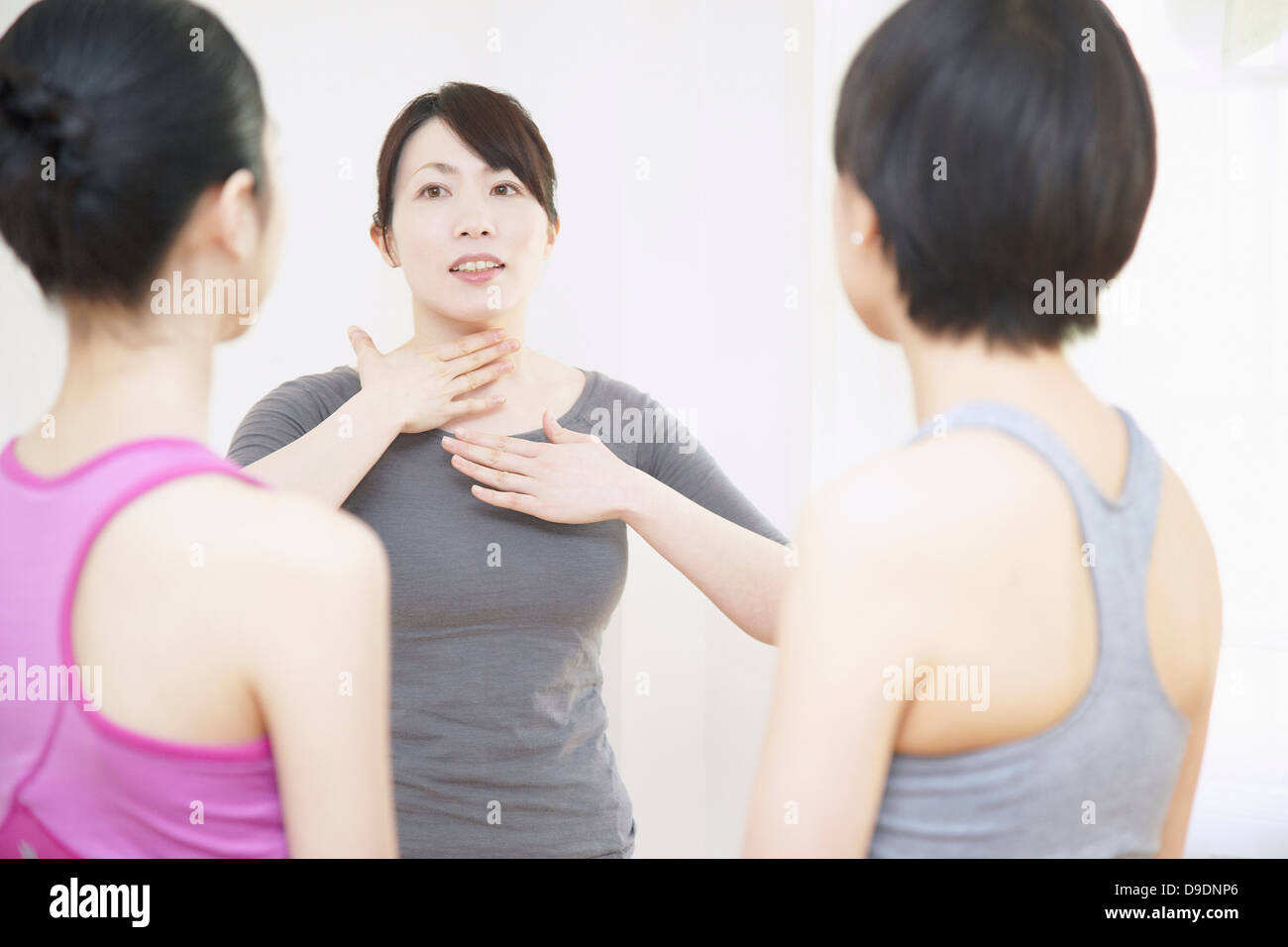 Yoga teacher demonstrating to young women Stock Photo - Alamy