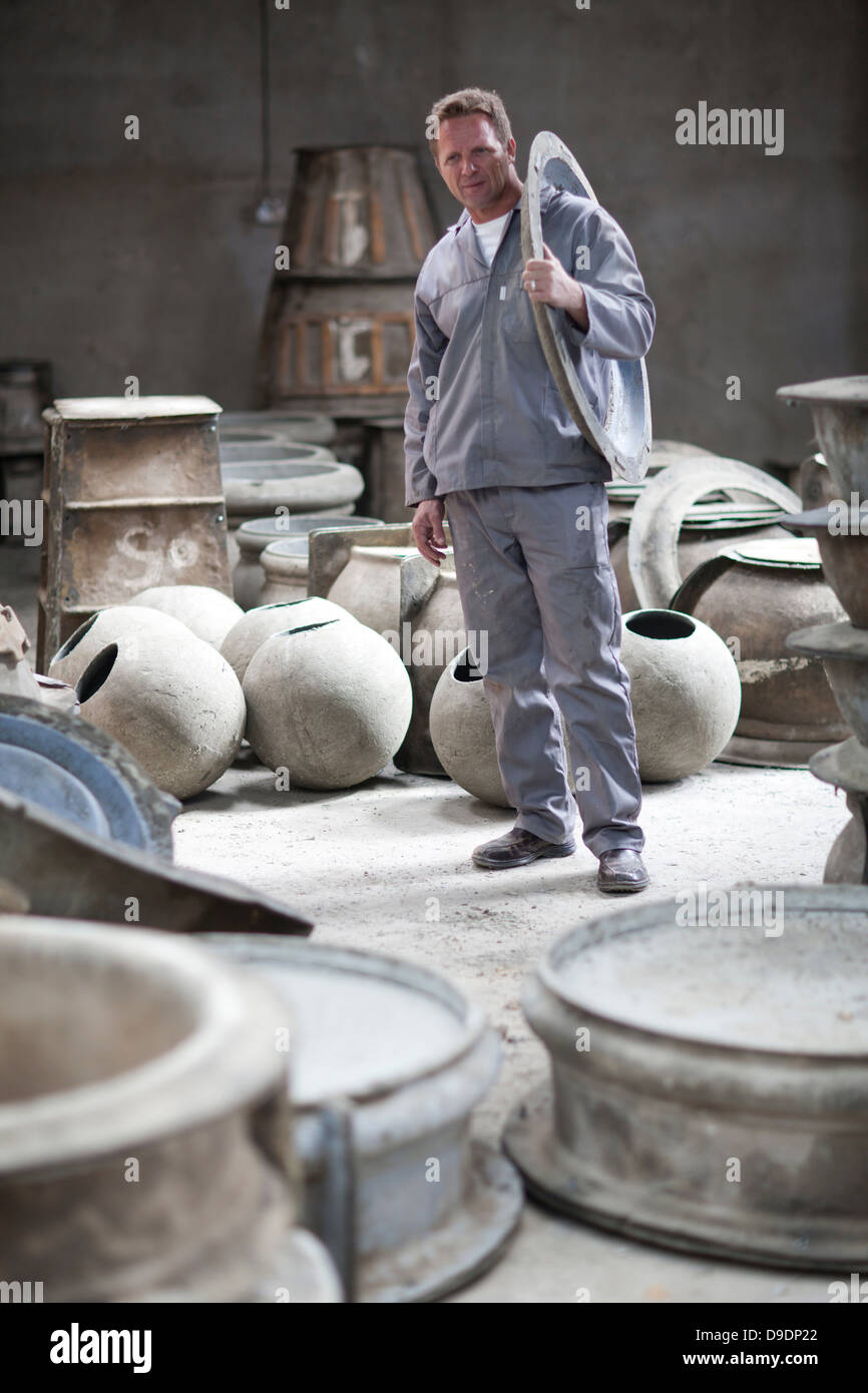 Factory worker carrying wheel Stock Photo - Alamy