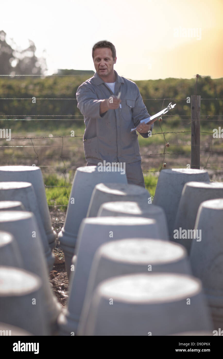 Factory worker pointing at large vases Stock Photo - Alamy