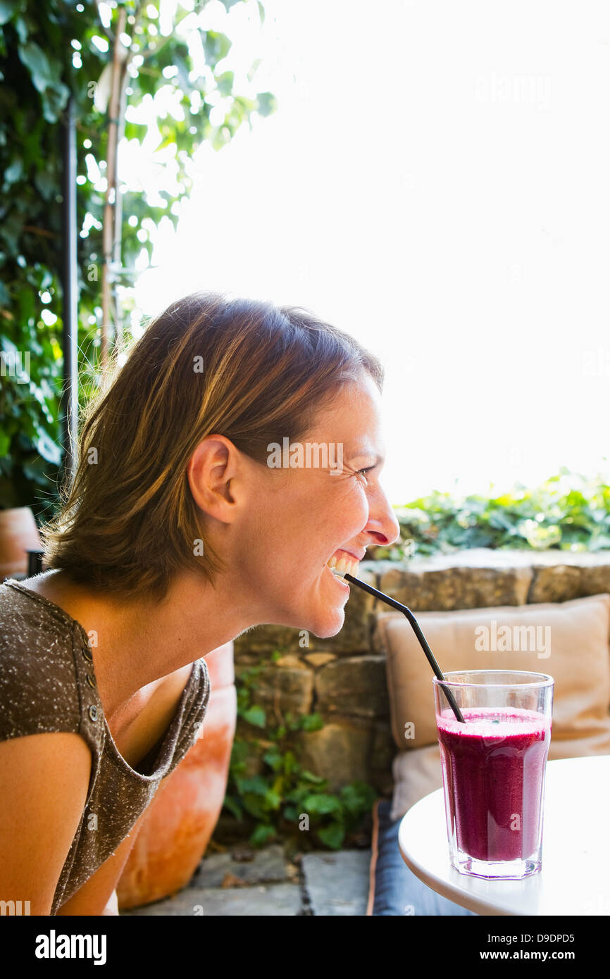 Woman drinking drink with straw Stock Photo - Alamy