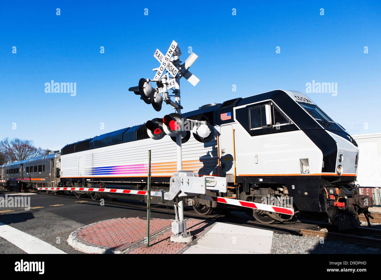 Passenger train passing level crossing Stock Photo - Alamy