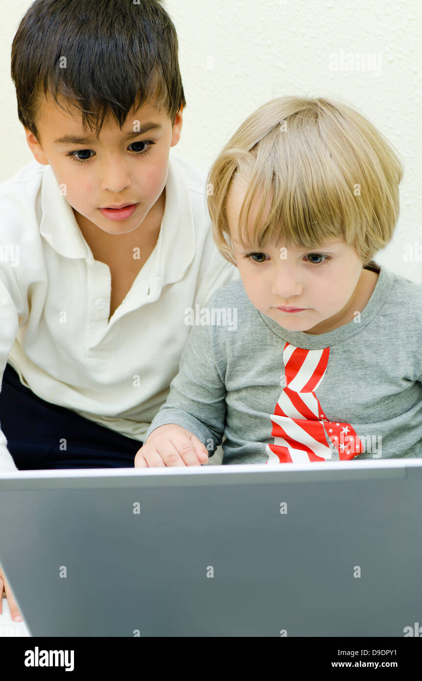 Two children staring at laptop Stock Photo - Alamy