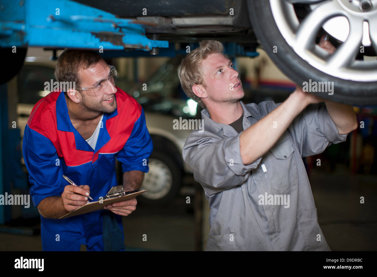 Car mechanics discussing analyzing car hi-res stock photography and ...