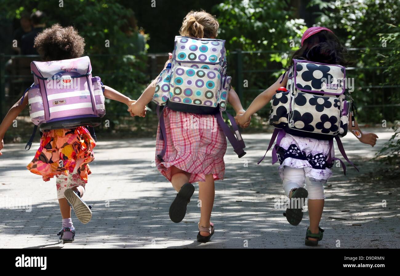 Three school children run out of the gate of their school after their ...