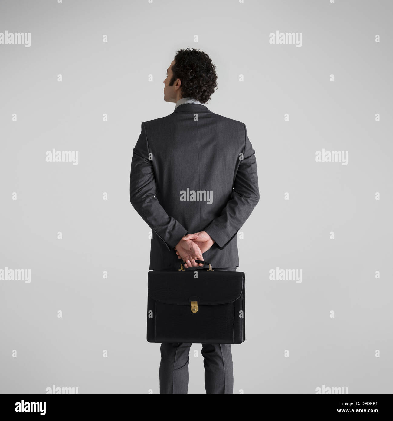 Man holding suitcase, rear view Stock Photo - Alamy