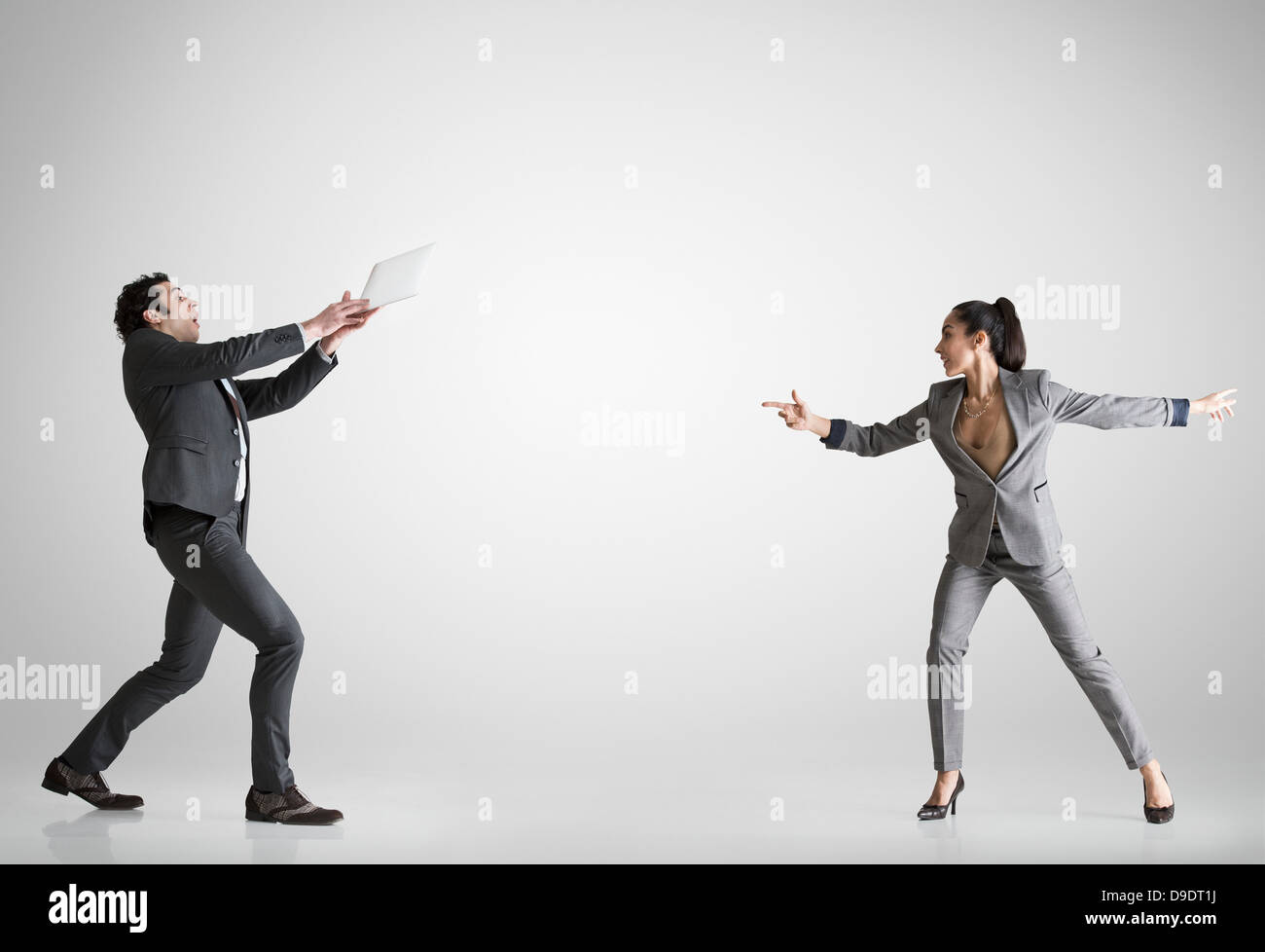 Woman throwing digital table to man Stock Photo - Alamy