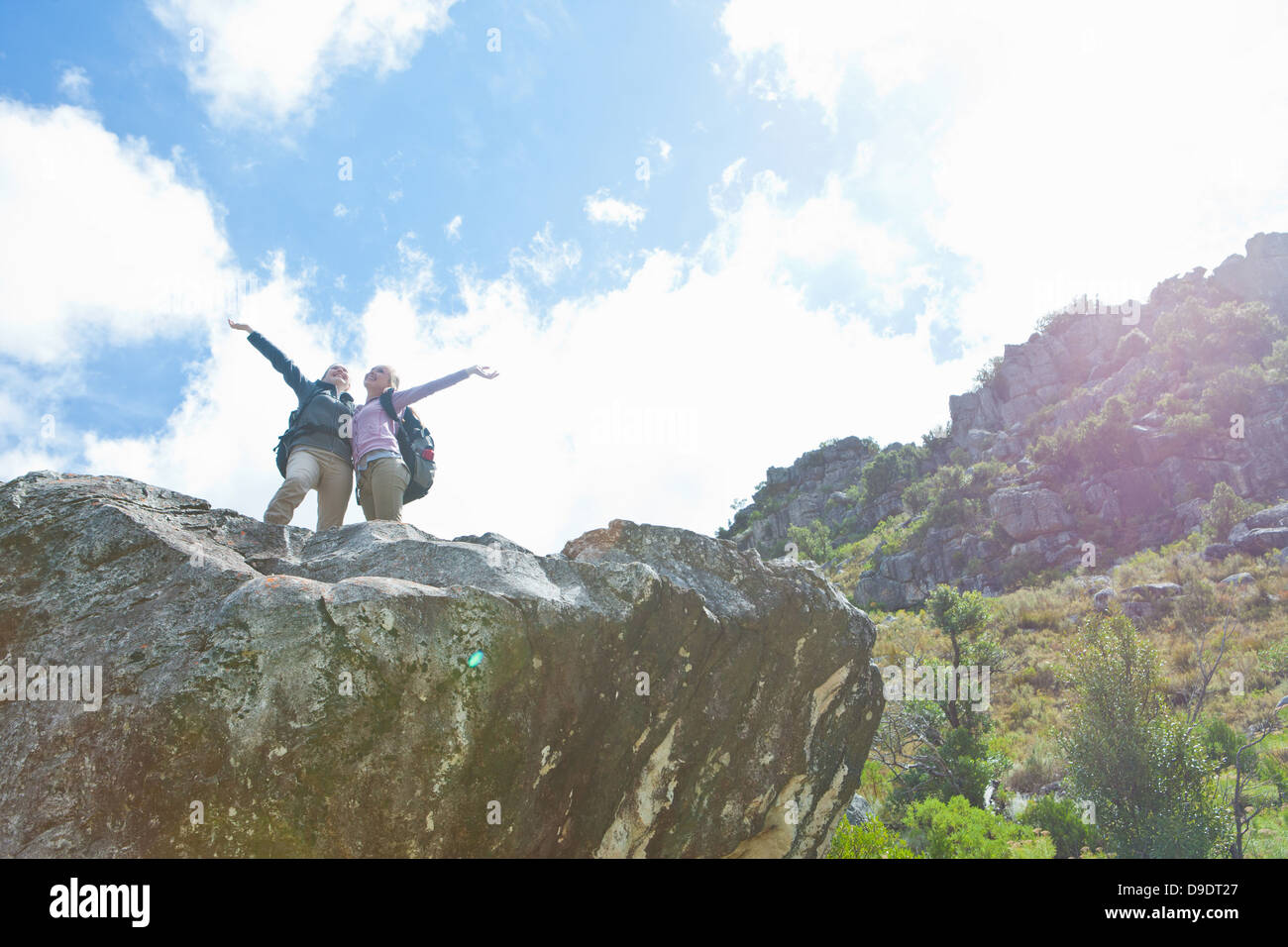 Two girl hikers celebrating on top of rock formation Stock Photo - Alamy