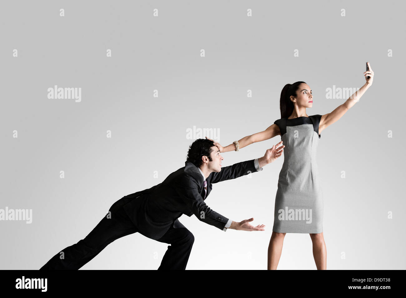 Woman with cell phone restraining man Stock Photo - Alamy