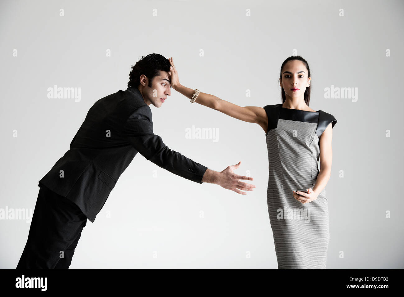 Woman with cell phone restraining man Stock Photo - Alamy