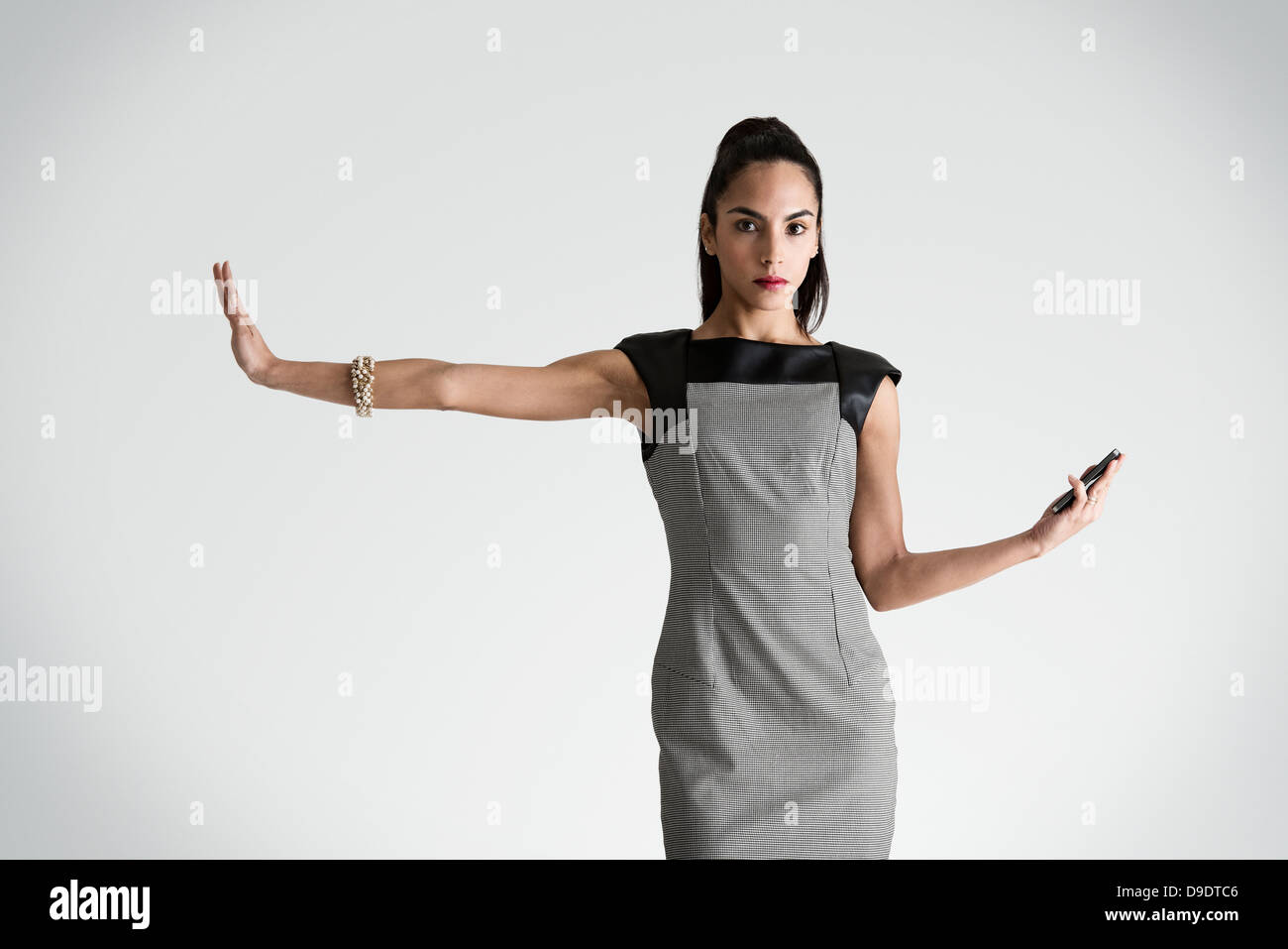 Woman with cell phone holding arm out Stock Photo - Alamy