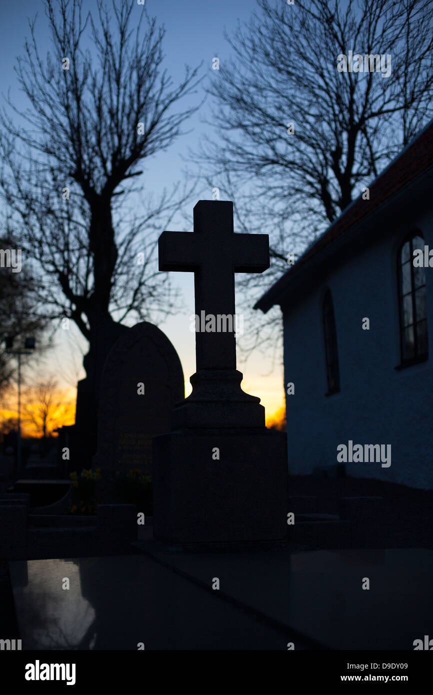A headstone shaped like a cross at sunset Stock Photo - Alamy