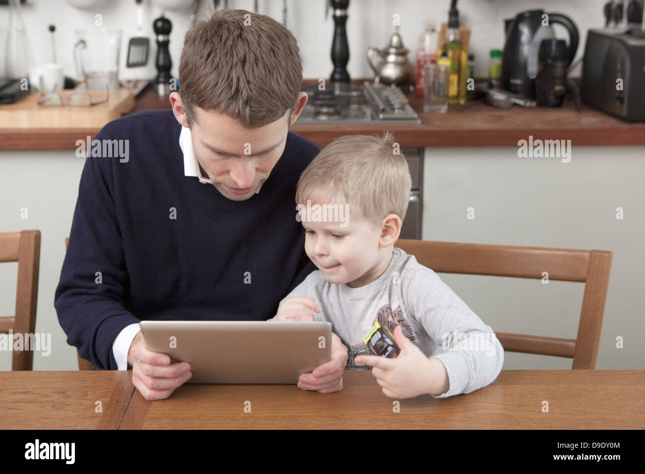 Father and son using digital tablet Stock Photo - Alamy