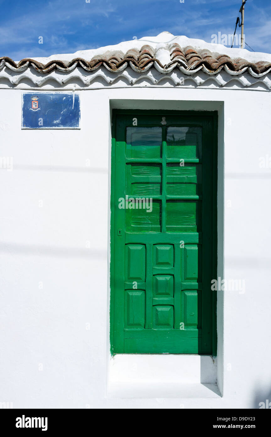 Old white building with green wooden door and street sign with no name ...