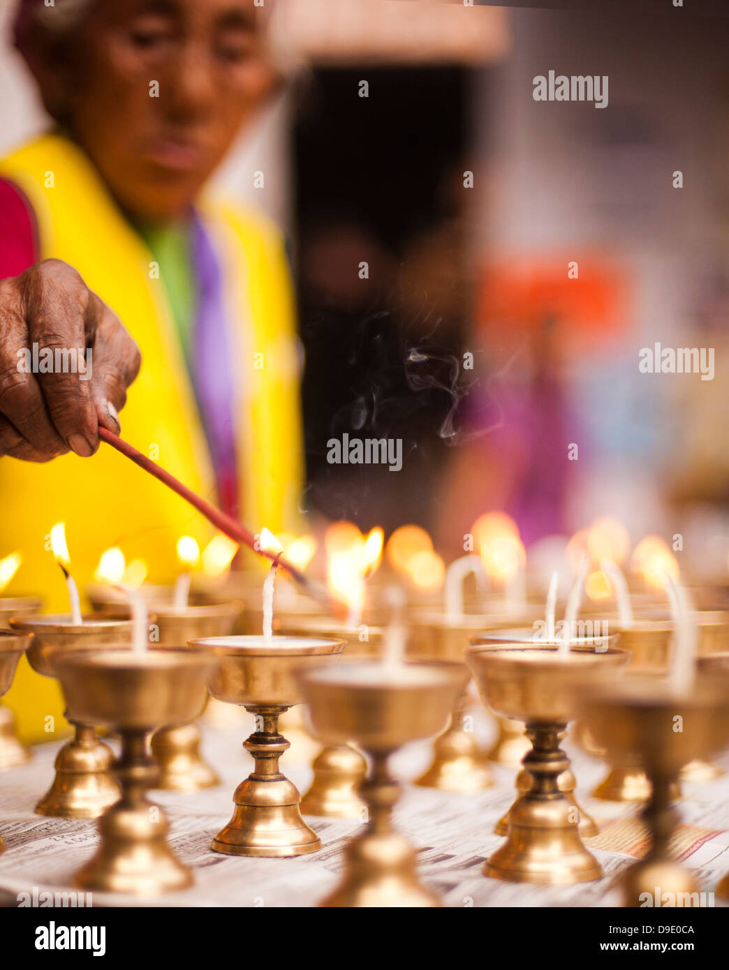 Woman lighting candle in a monastery, Tibetan Monastery, Delhi, India ...