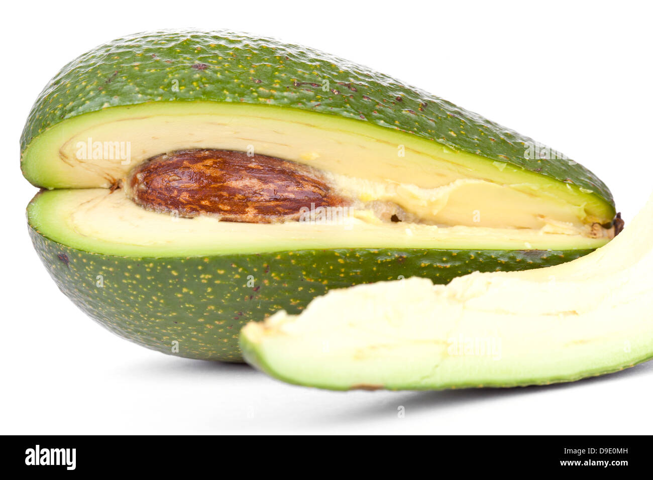 Whole avacado and slice closeup on white Stock Photo - Alamy