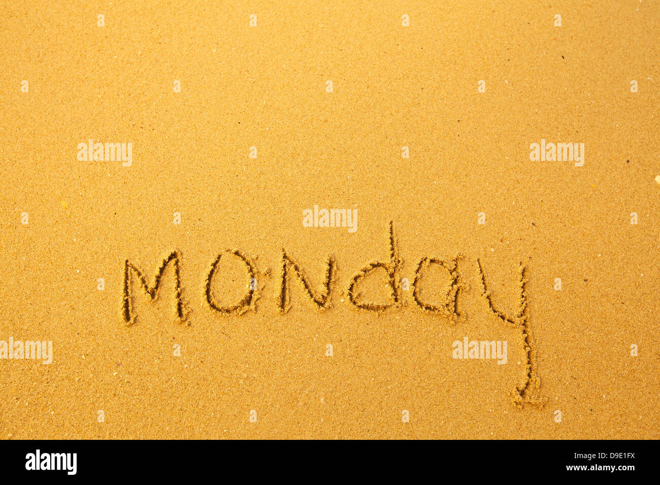 Monday - written in sand on beach texture Stock Photo - Alamy