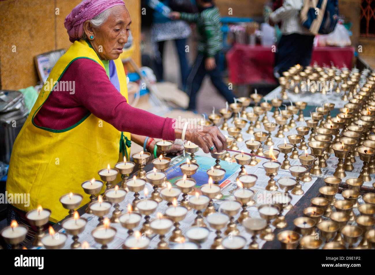 Woman lighting candle in a monastery, Tibetan Monastery, Delhi, India ...