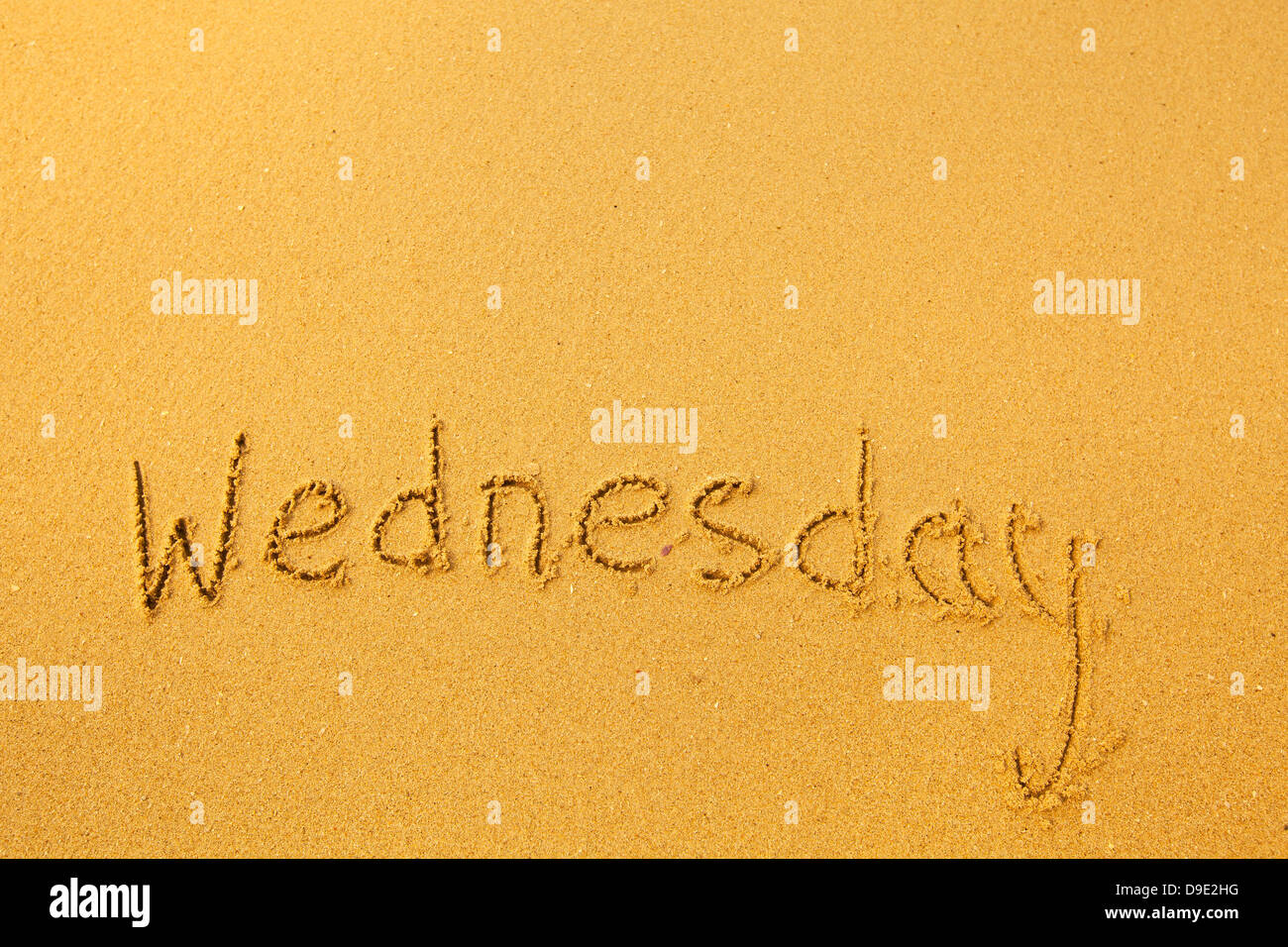 Wednesday - written in sand texture Stock Photo - Alamy