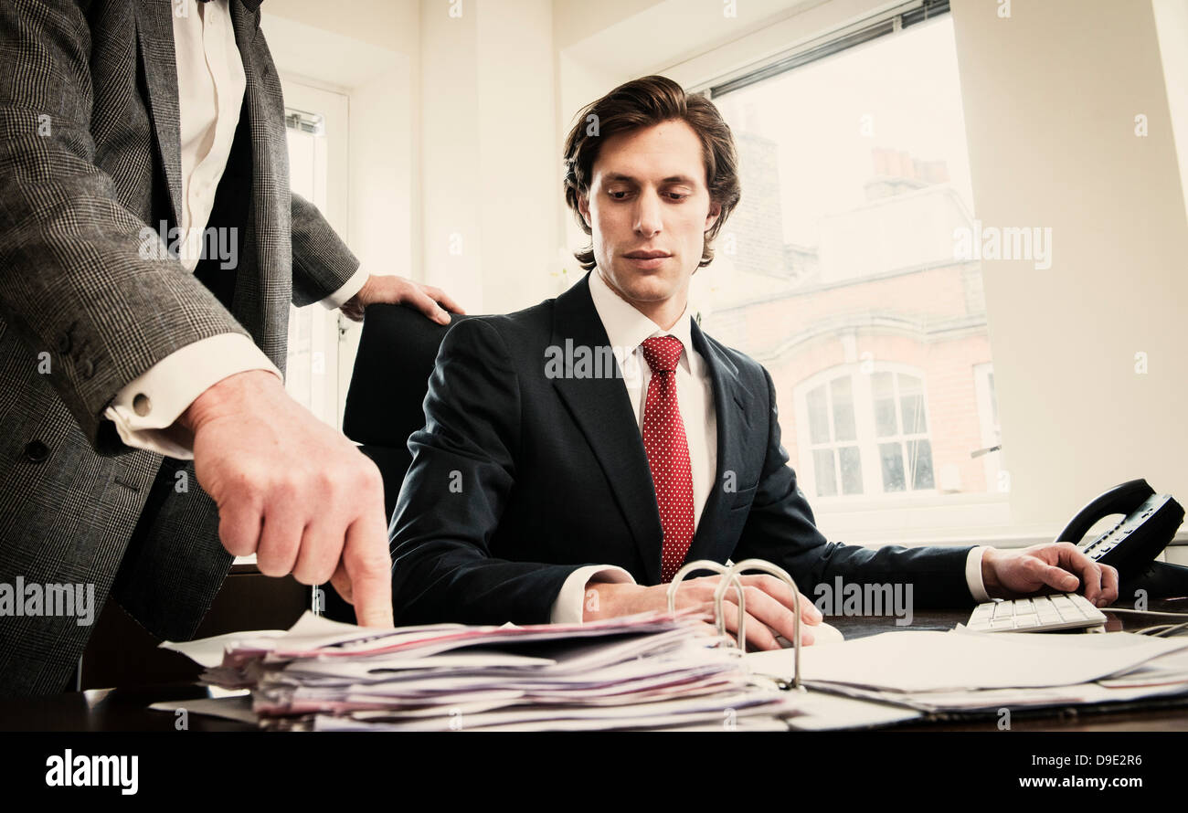 Man pointing at paperwork in ring binder Stock Photo - Alamy
