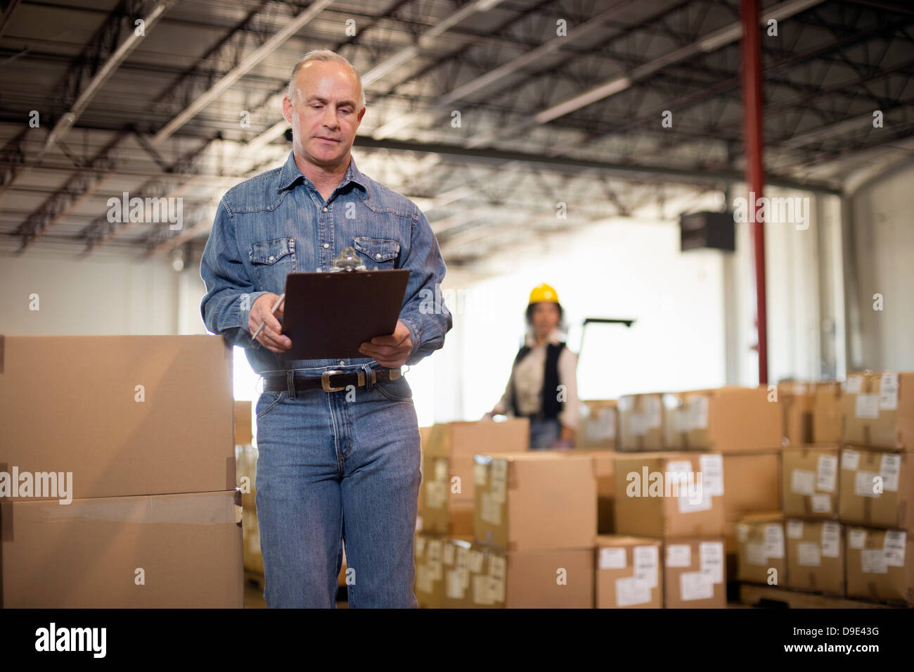 Male warehouse worker holding clipboard Stock Photo - Alamy