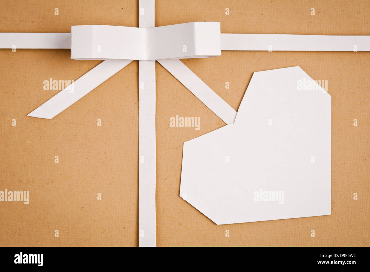 Hand made ribbon with bow and heart on kraft paper as background ...