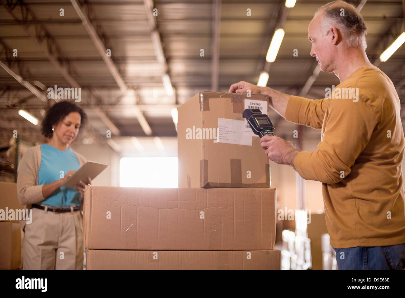 Man with barcode reader and cardboard boxes Stock Photo - Alamy