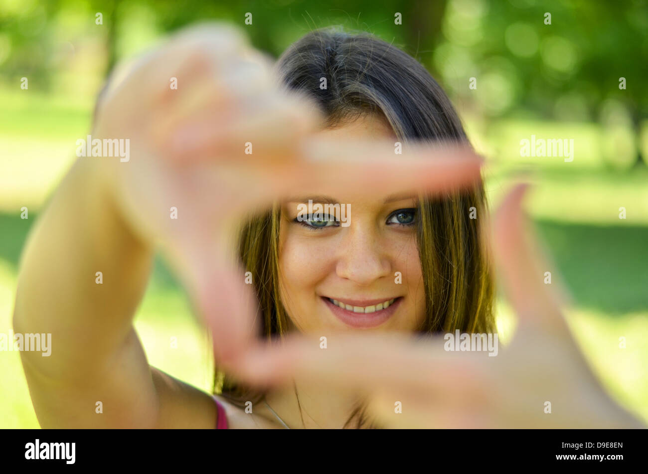 Beautiful girl making frame with hands while outdoors Stock Photo - Alamy