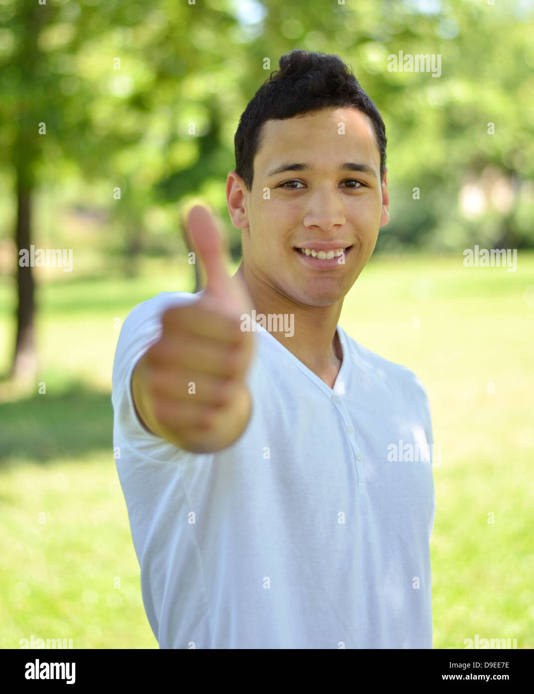 Young smiling with thumb up against nature background Stock Photo - Alamy