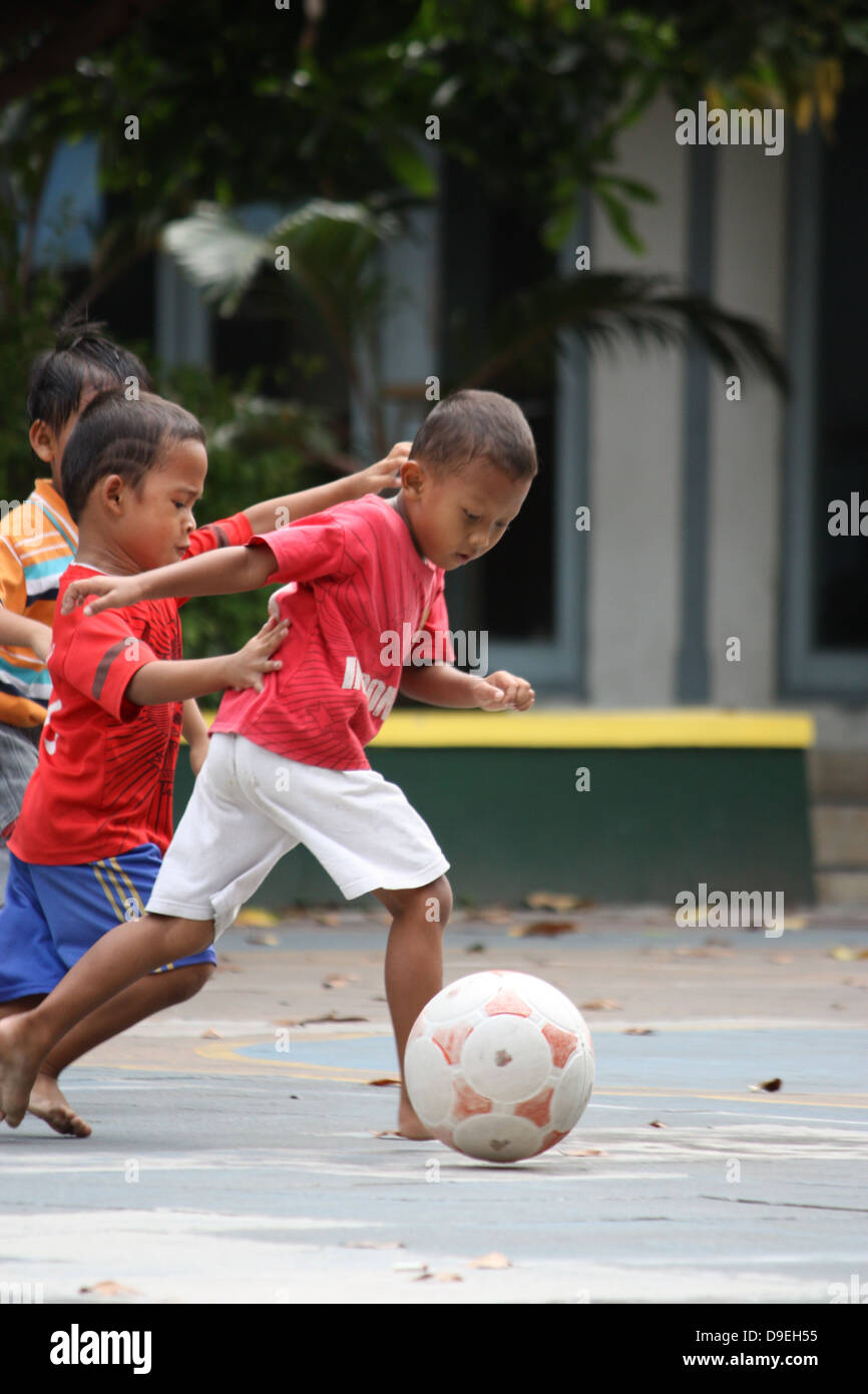 three children fighting for the ball Stock Photo - Alamy
