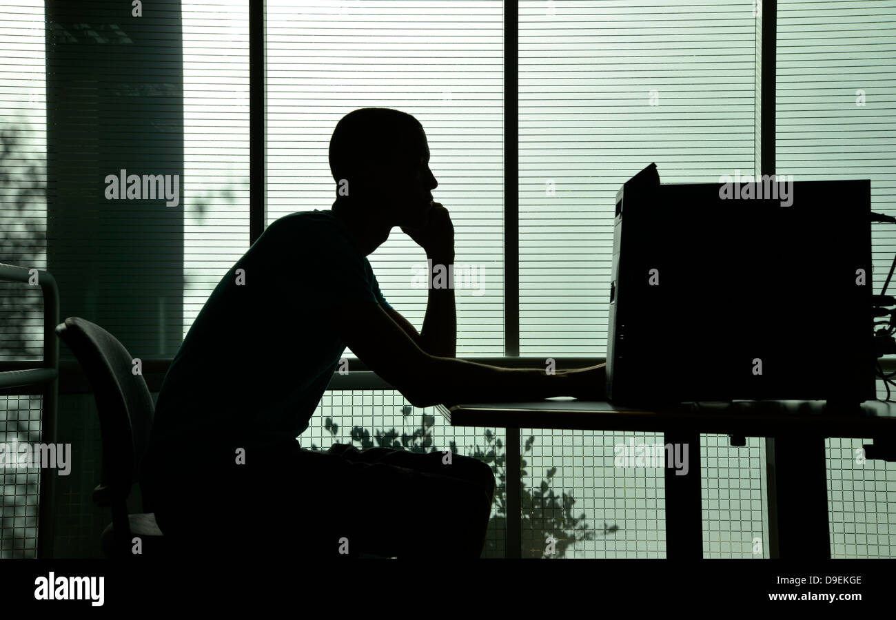 A young man works on a computer on a college campus Stock Photo - Alamy