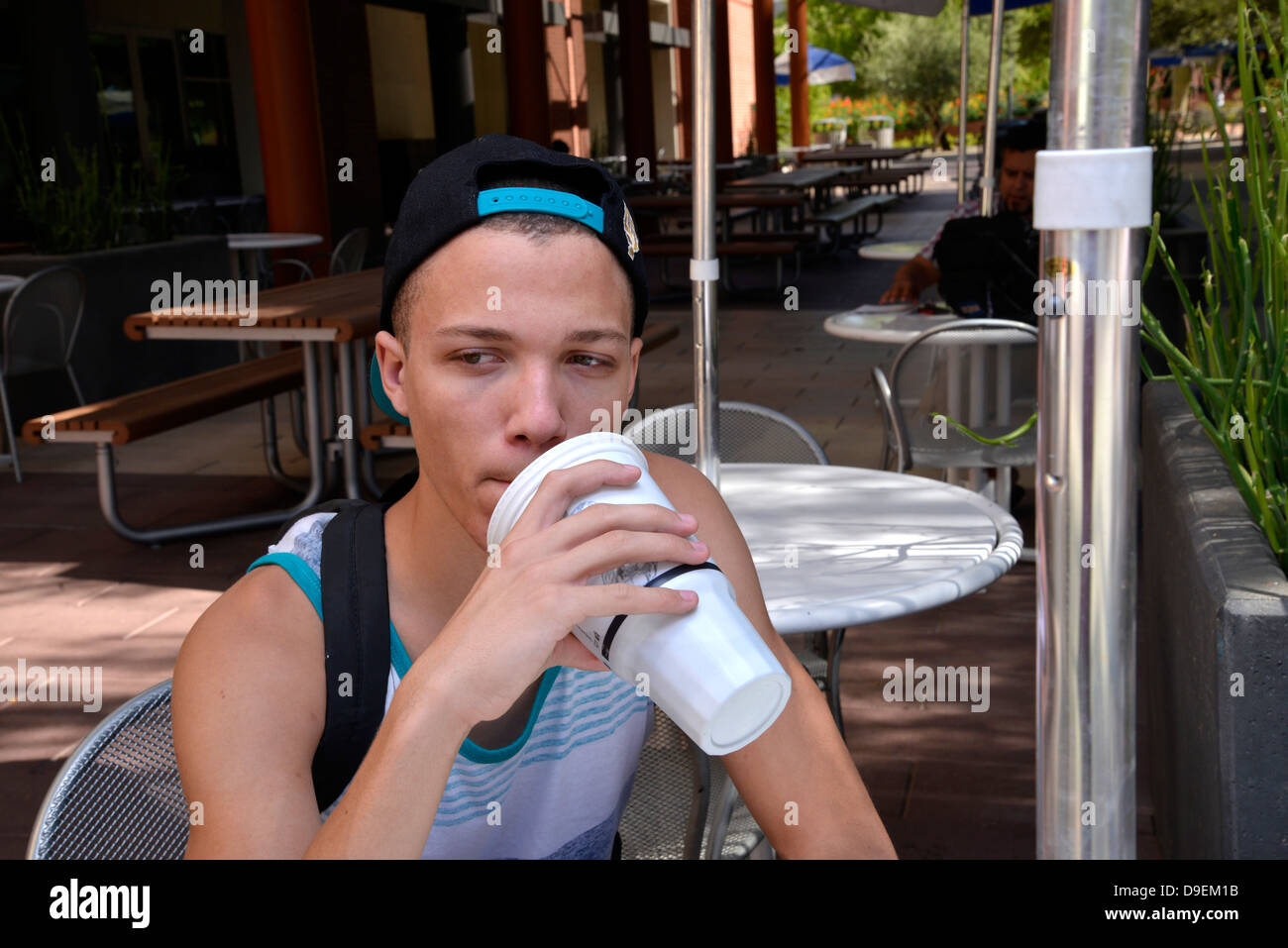 A young man drinks soda on a college campus Stock Photo - Alamy