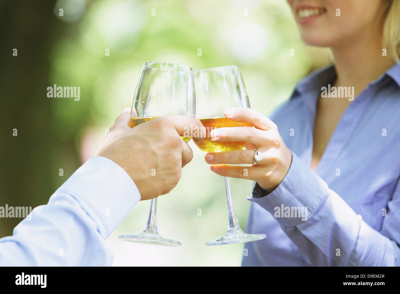 Couple cheering with white wine Stock Photo - Alamy