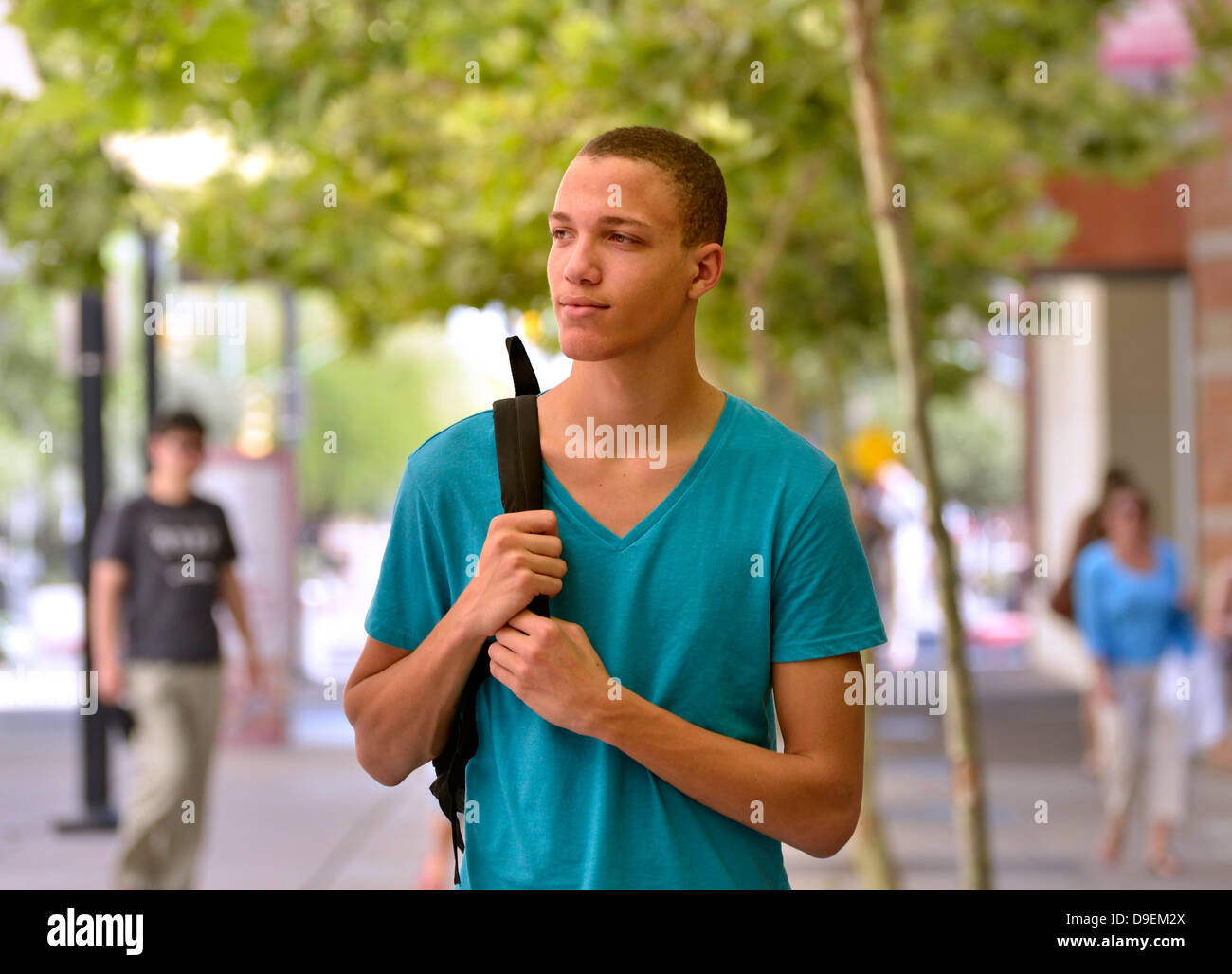 A young man walks on a college campus Stock Photo - Alamy