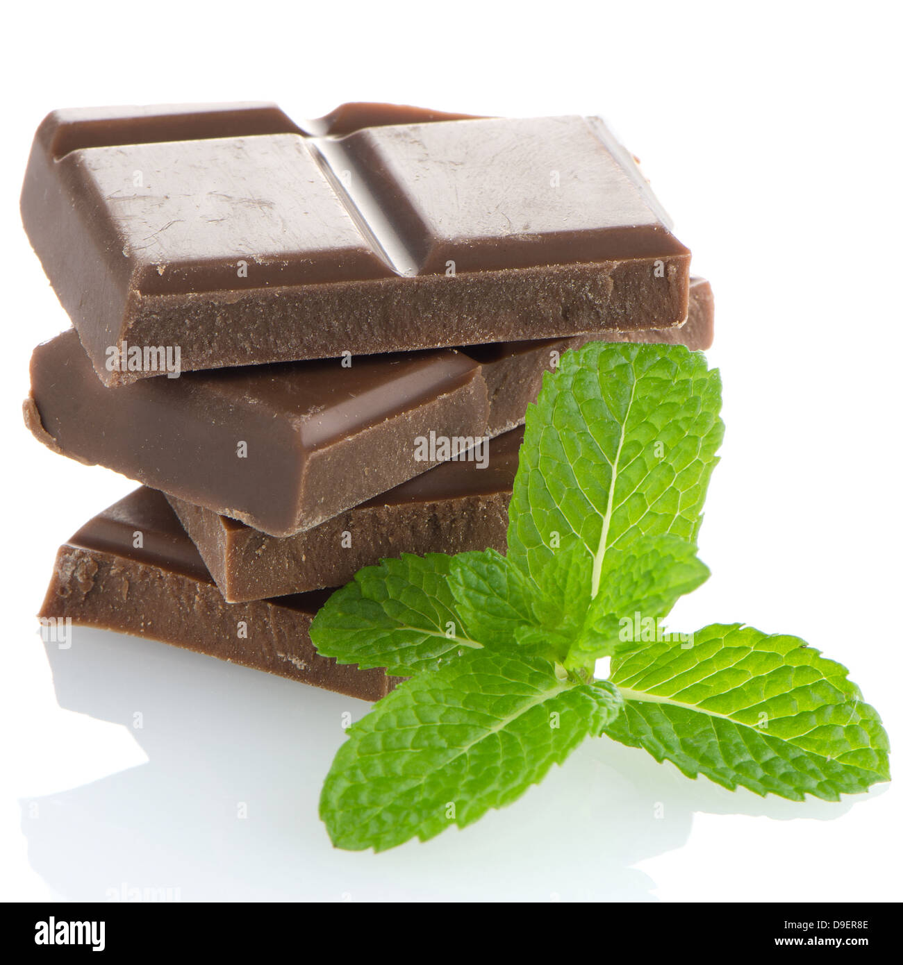Closeup detail of chocolate parts and mint leaves on white background ...