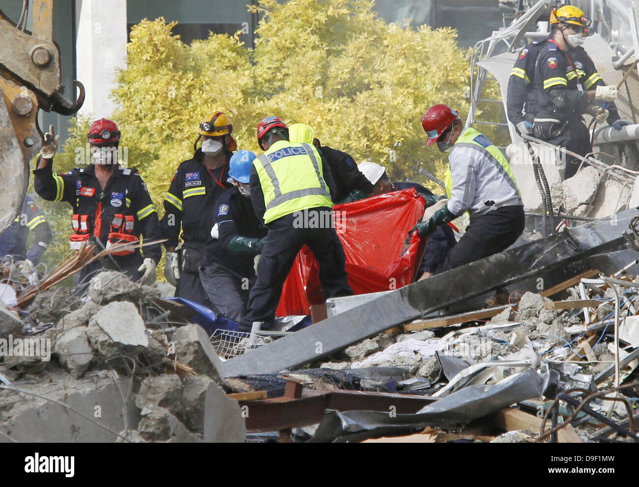 Rescue workers search through the rubble of the collapsed CTV building ...
