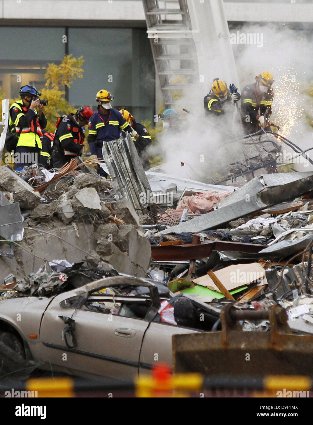 Rescue workers search through the rubble of the collapsed CTV building ...