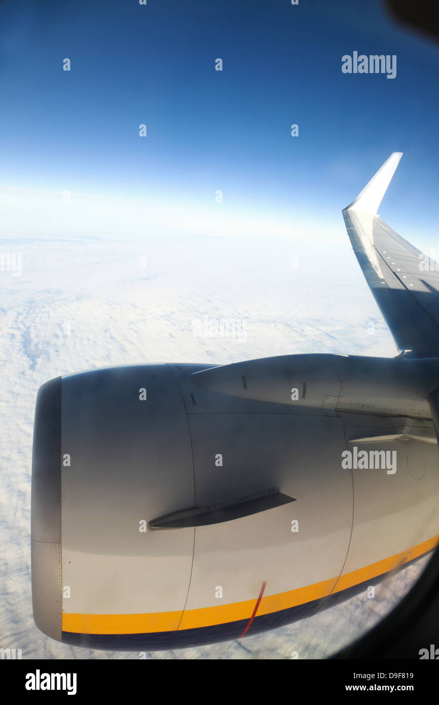Airplane in the blue sky engine and wings white clouds Stock Photo - Alamy