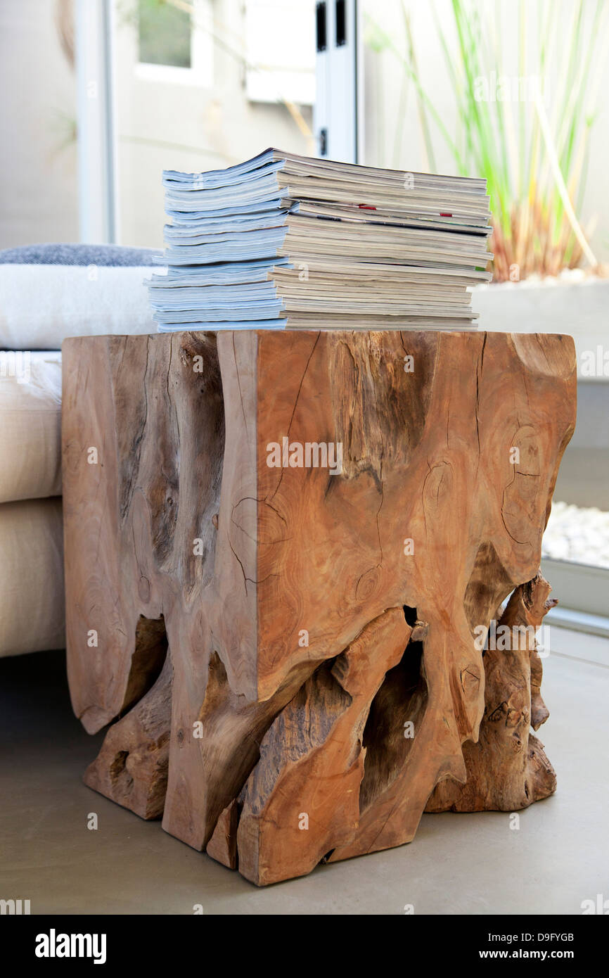 Stack of magazines on a table made from tree stump Stock Photo - Alamy